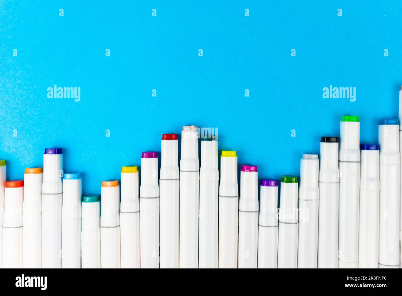 Many white assorted markers stacked on a blue background. Place for ...