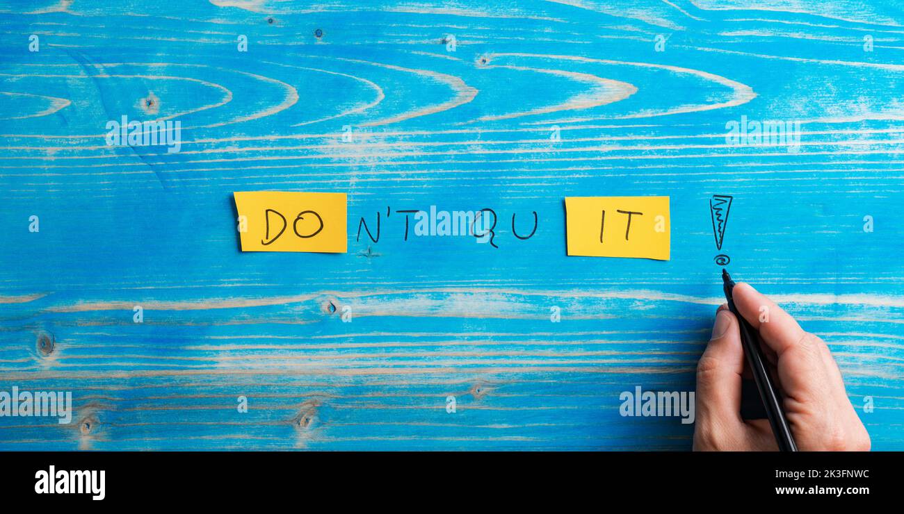 Male hand writing a Dont quit, Do it sign on bright yellow papers over ...