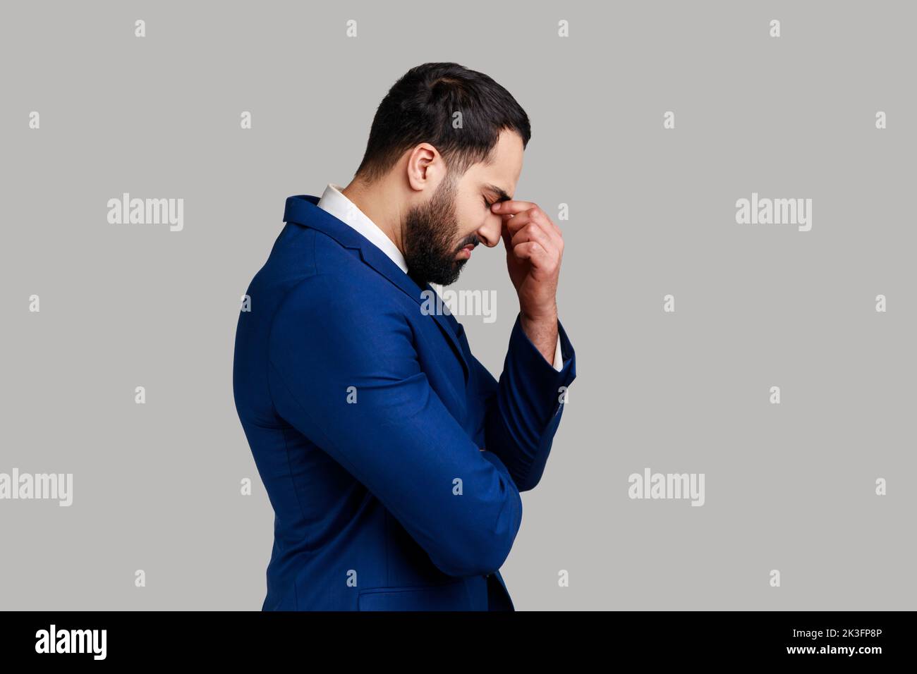 Side view of sad upset unhappy bearded businessman hiding face in hand ...