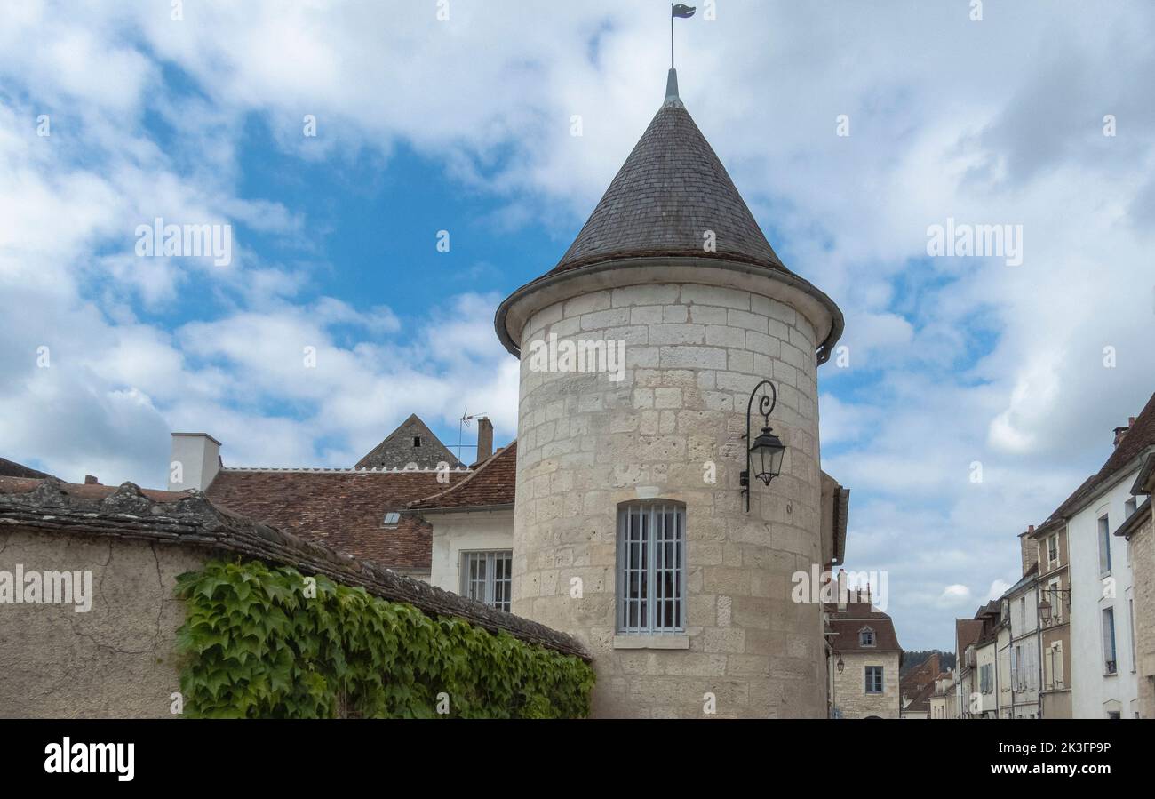 Round tower made of pale coloured stone at the entrance to a village ...