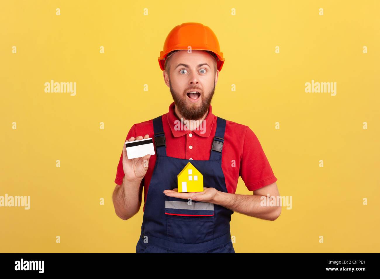 Portrait of shocked builder man wearing blue uniform and protective ...