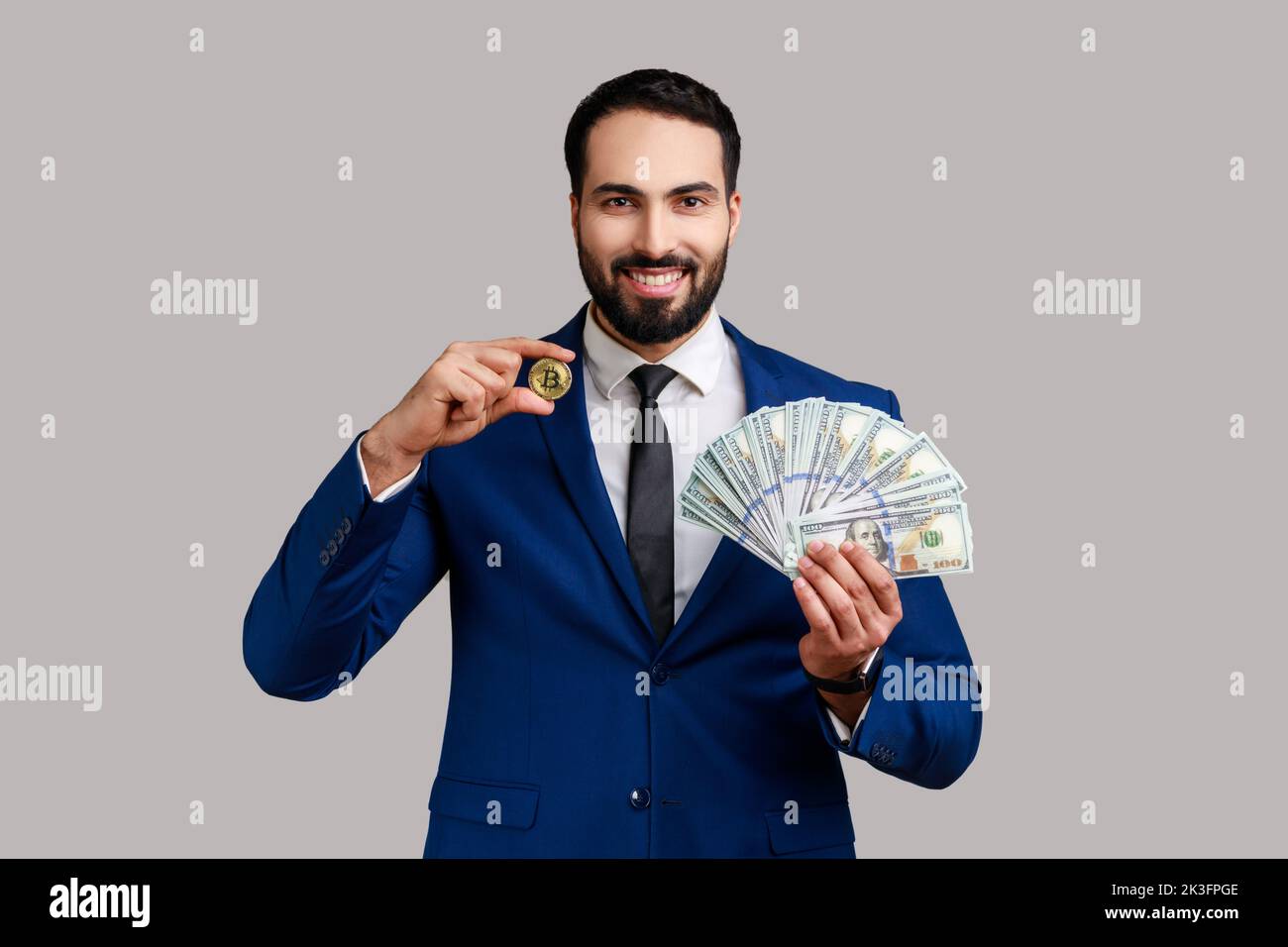 Man holding in hands and showing dollar bills and golden coin of crypto ...