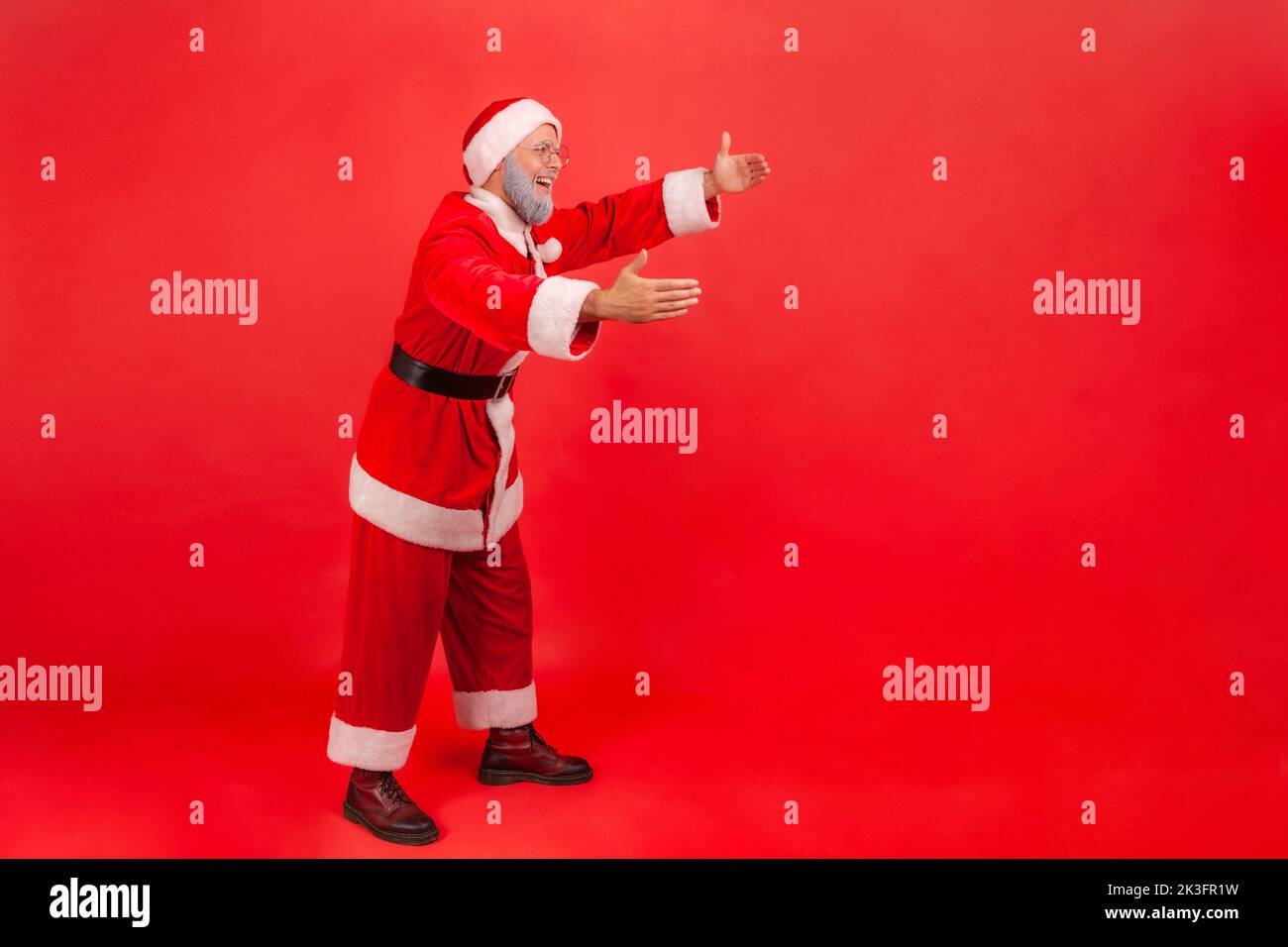 Full length profile shot of elderly man with gray beard wearing santa ...