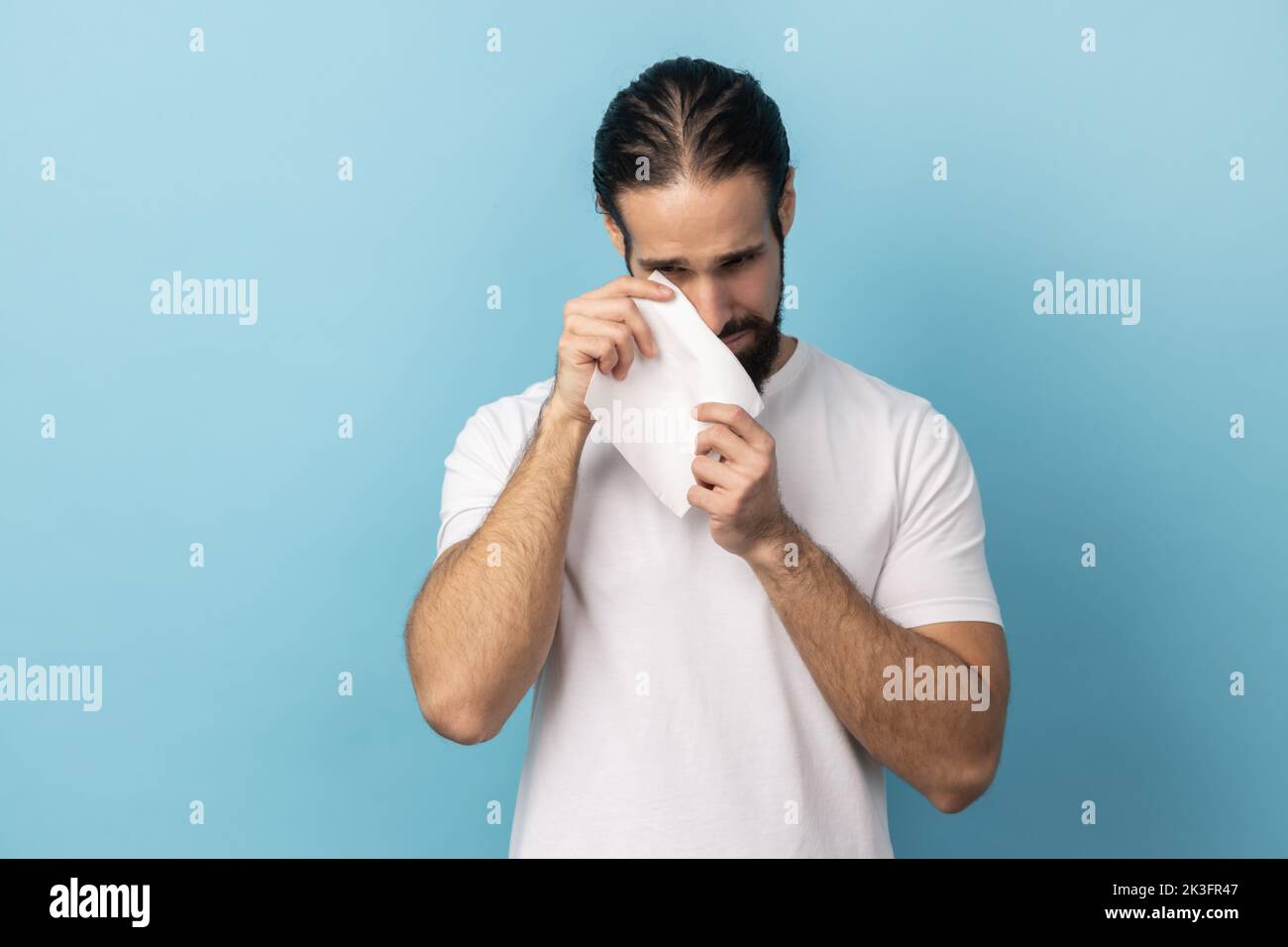 Portrait of sad upset handsome man with beard wearing white T-shirt ...