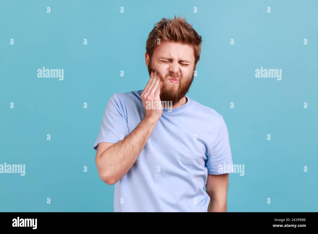 Portrait of unhealthy sick bearded man pressing sore cheek, suffering ...