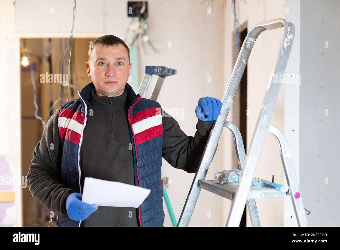 Repair man standing in apartment with documentation Stock Photo - Alamy