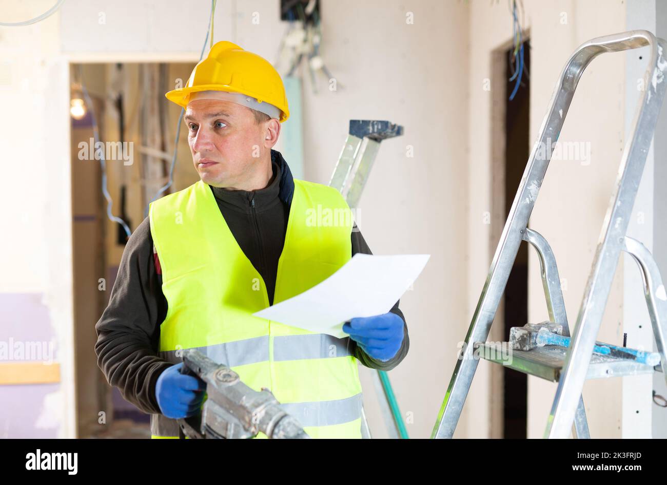 Male contractor looking at room and determining scope of building work ...
