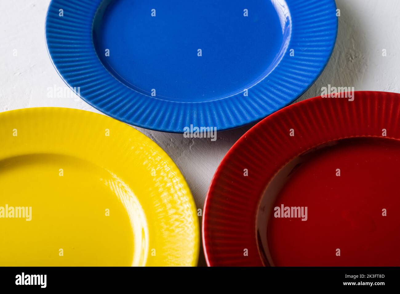 Different colors of empty plates. White background. Red, blue and ...