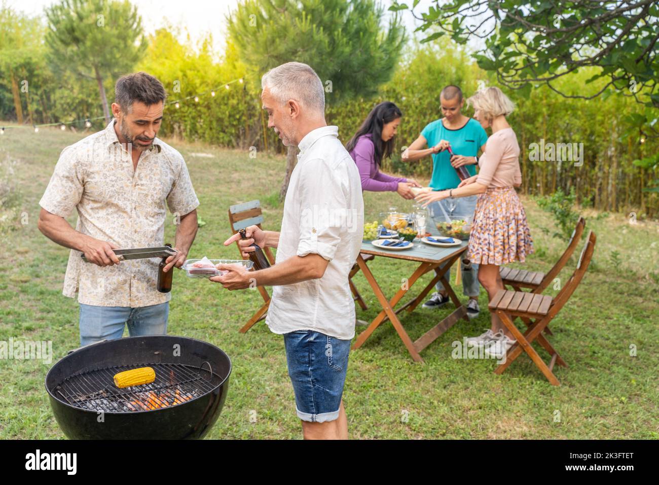 Mature people around the barbecue smiling happy and laughing together ...