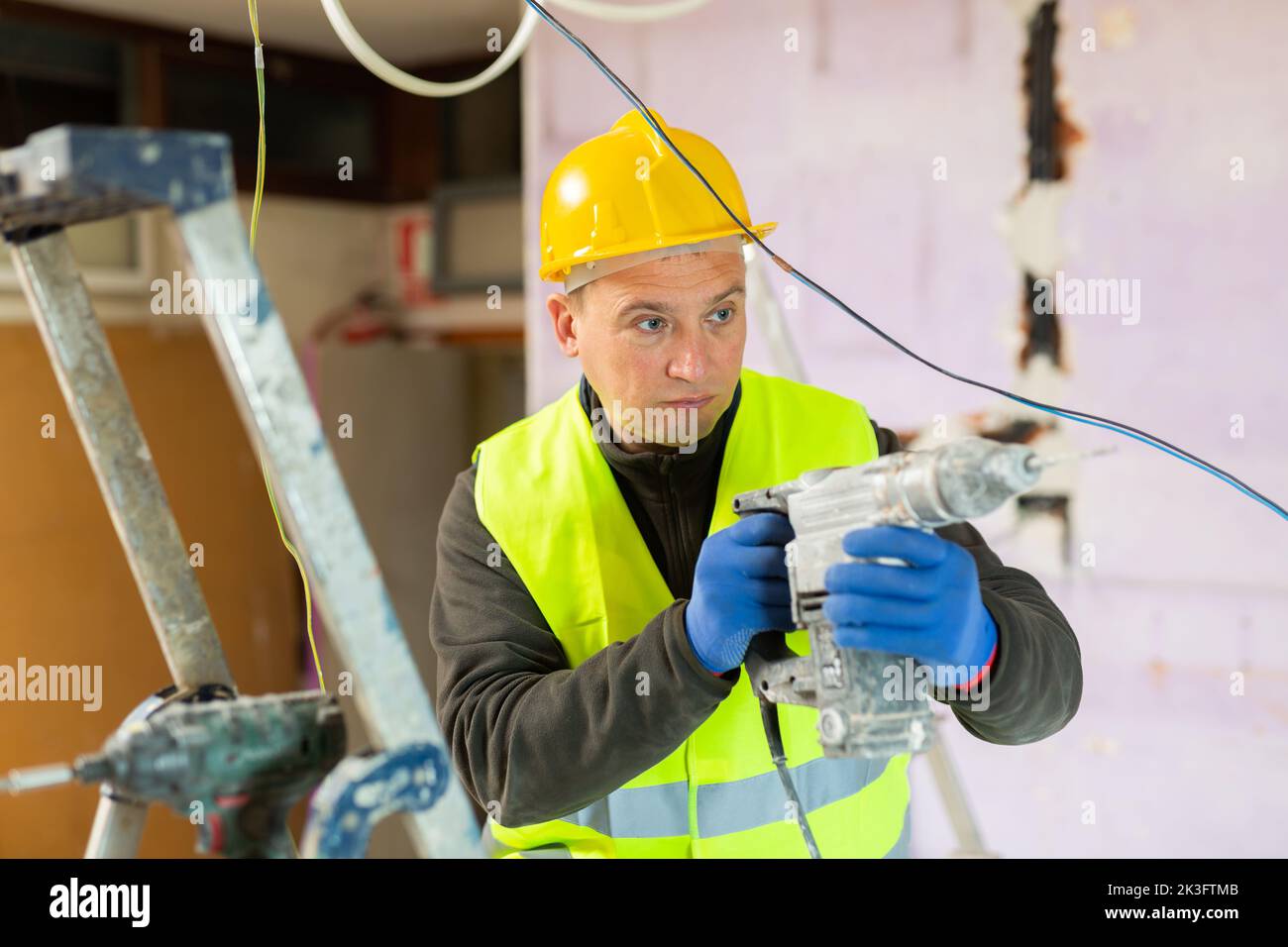 Male contractor holding electric perforator ready for construction ...