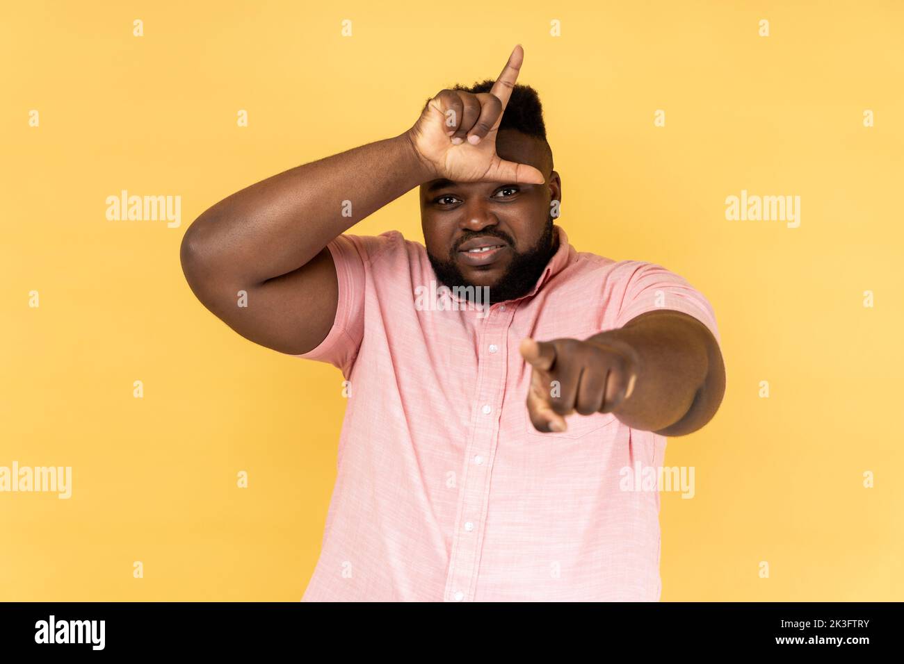 Portrait of handsome sad frustrated man wearing pink shirt showing ...