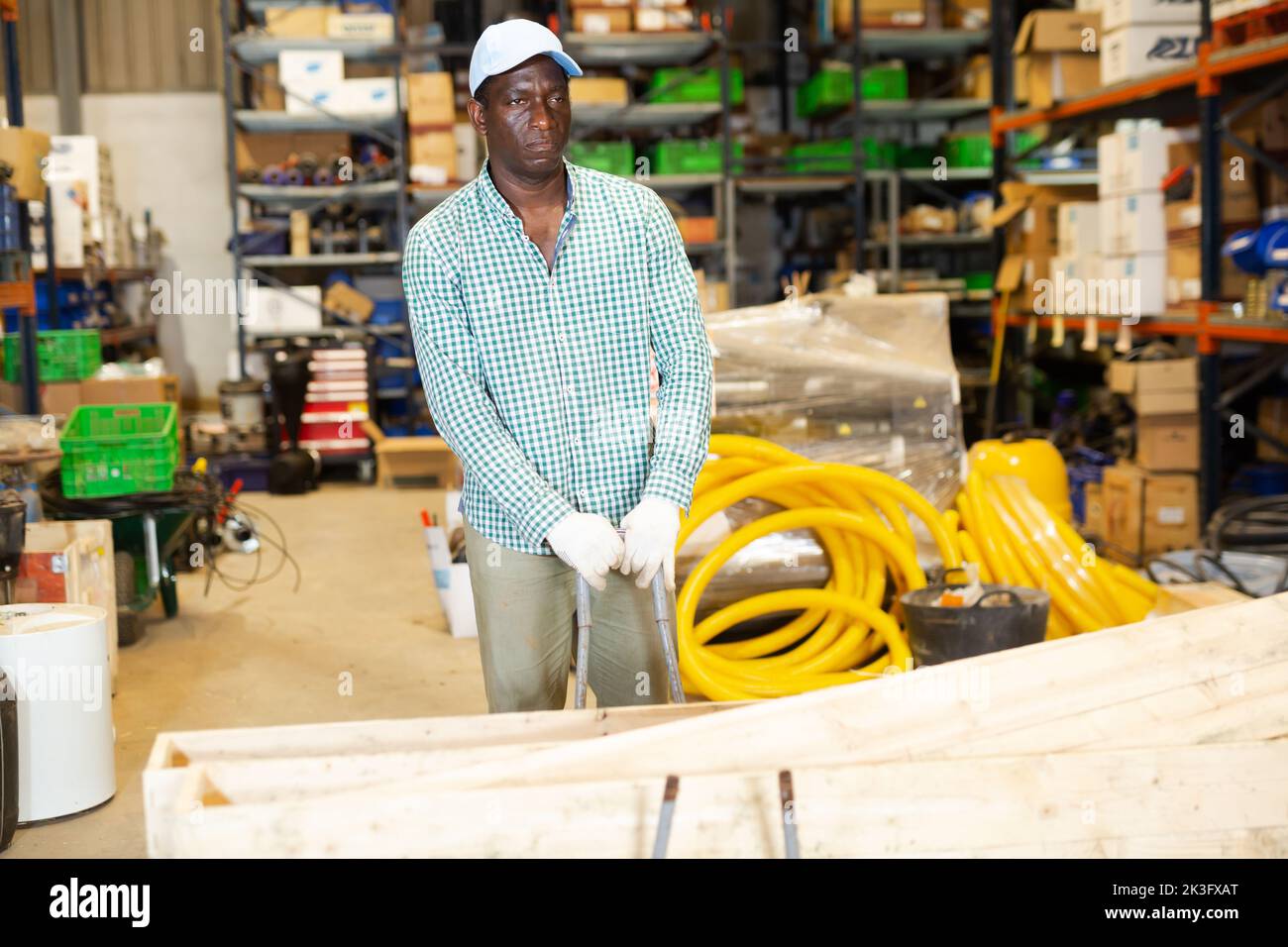 Warehouse worker pushing cart with planks Stock Photo - Alamy
