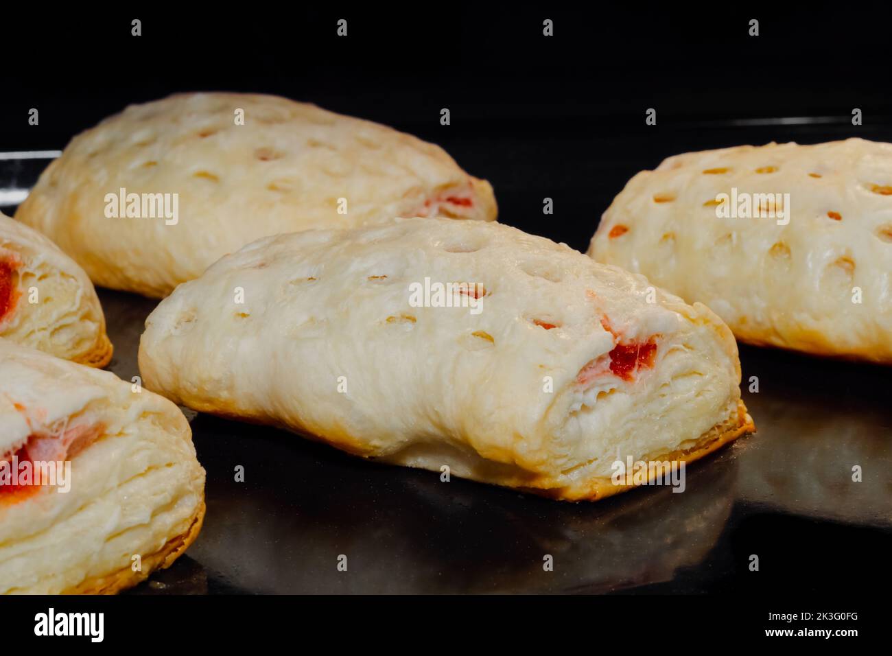 Homemade buns with red strawberry jam baking in electric oven Stock ...