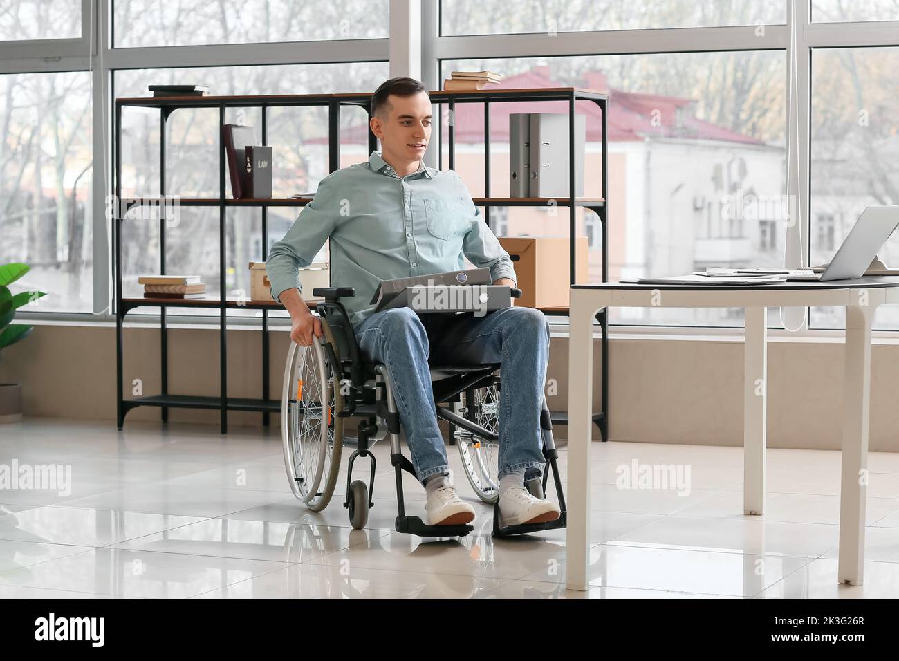 Young man with physical disability working in office Stock Photo - Alamy