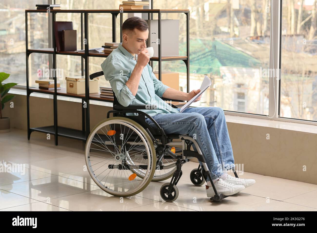 Young man with physical disability working in office Stock Photo - Alamy