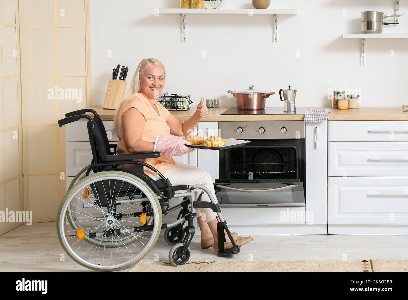 Mature woman with physical disability baking pastry in kitchen Stock ...