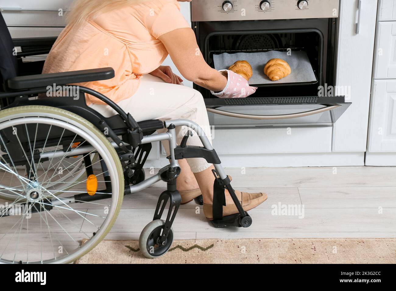Mature woman with physical disability baking pastry in kitchen Stock ...