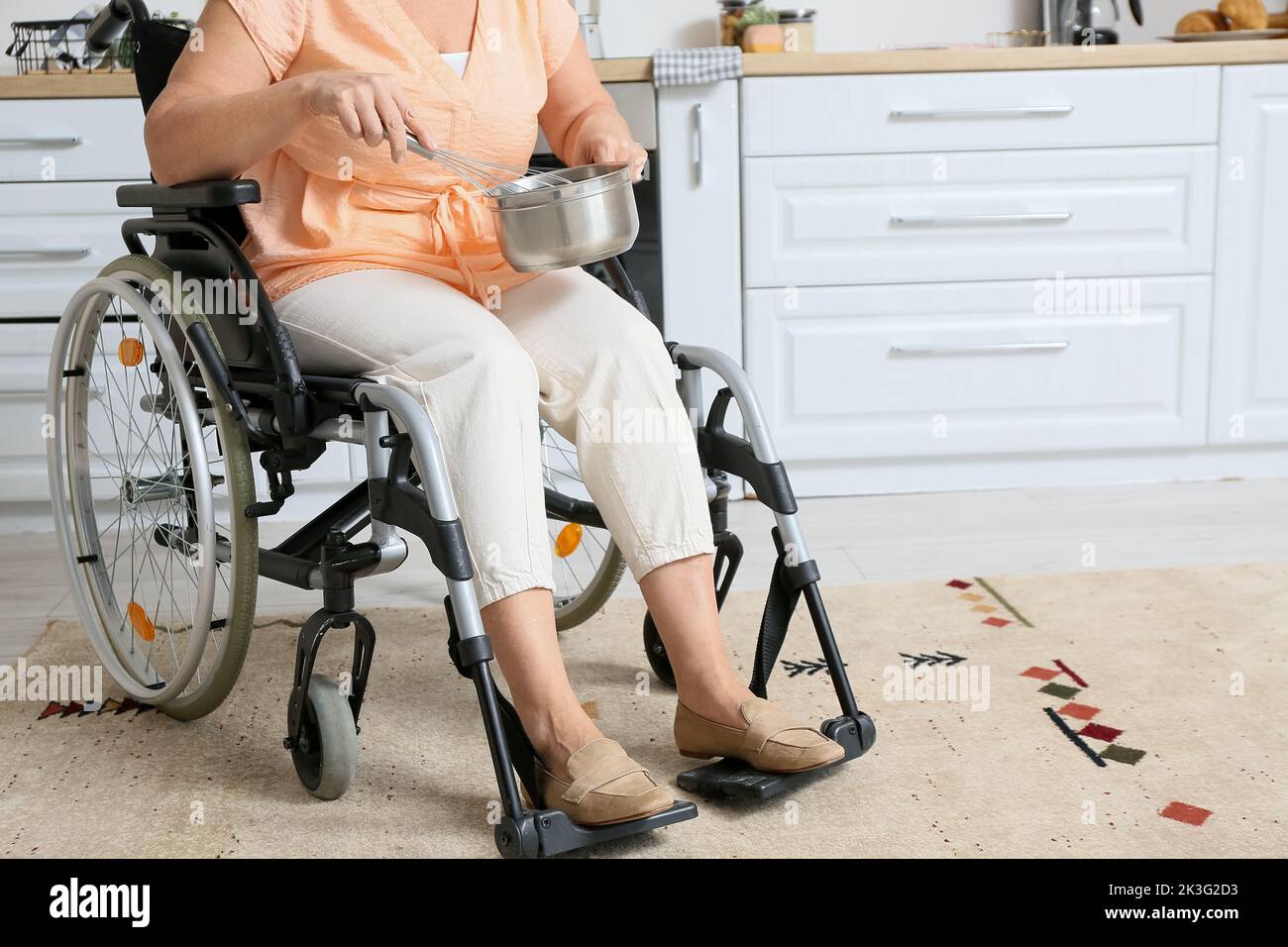 Mature woman with physical disability cooking in kitchen Stock Photo ...