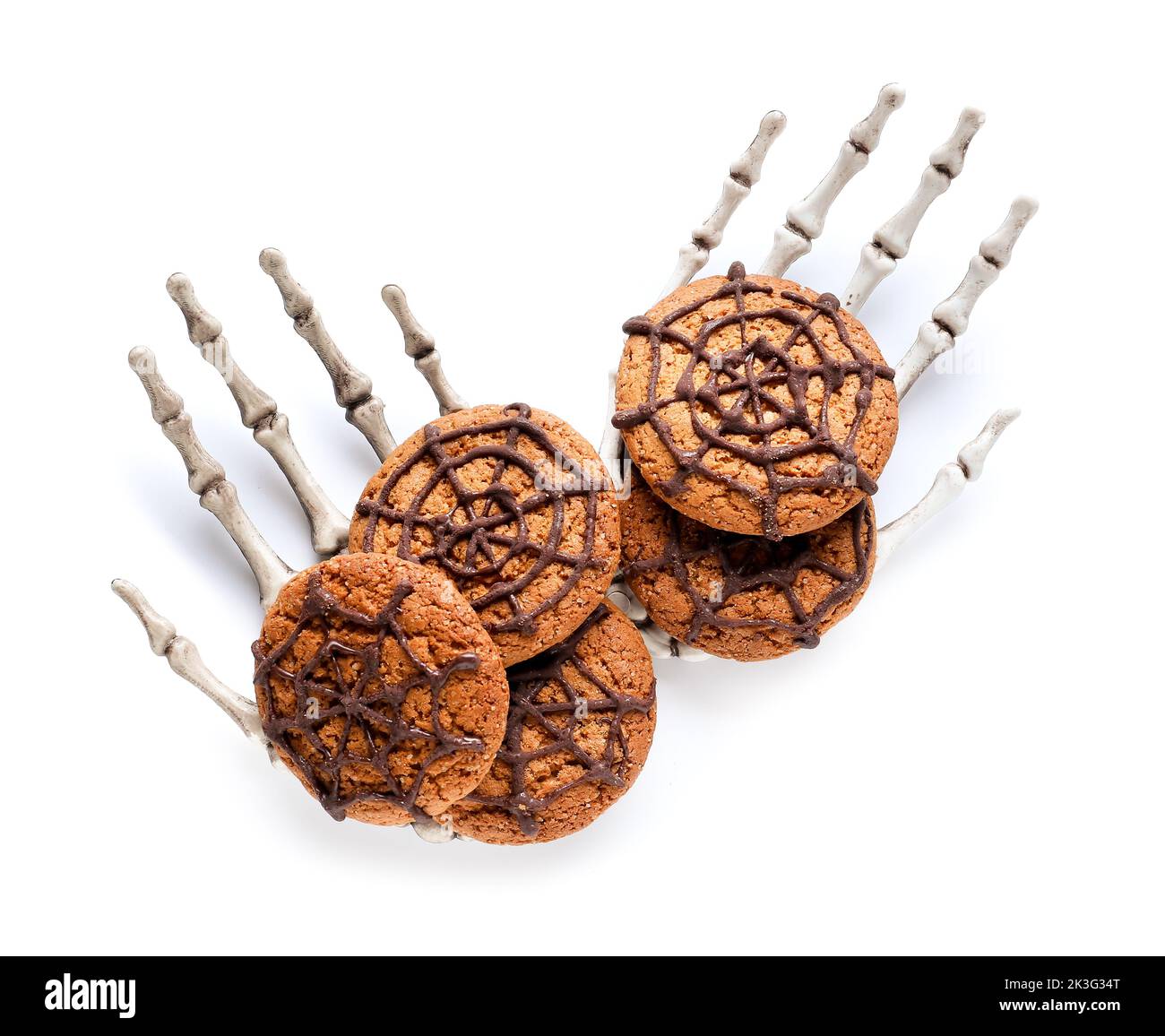 Halloween spiderweb cookies and skeleton hands on white background ...