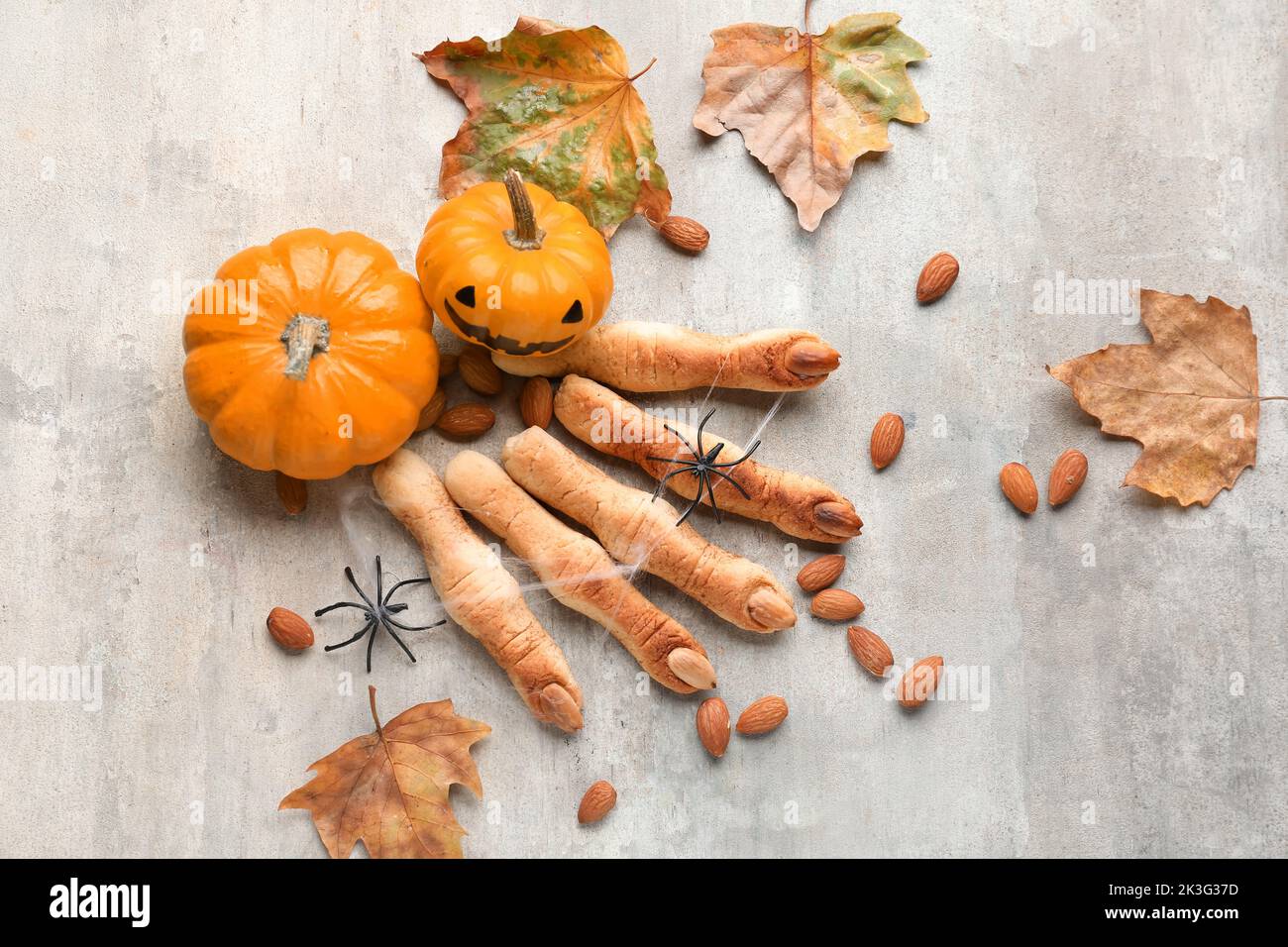 Halloween cookies with almond nuts, pumpkins and fallen leaves on light ...