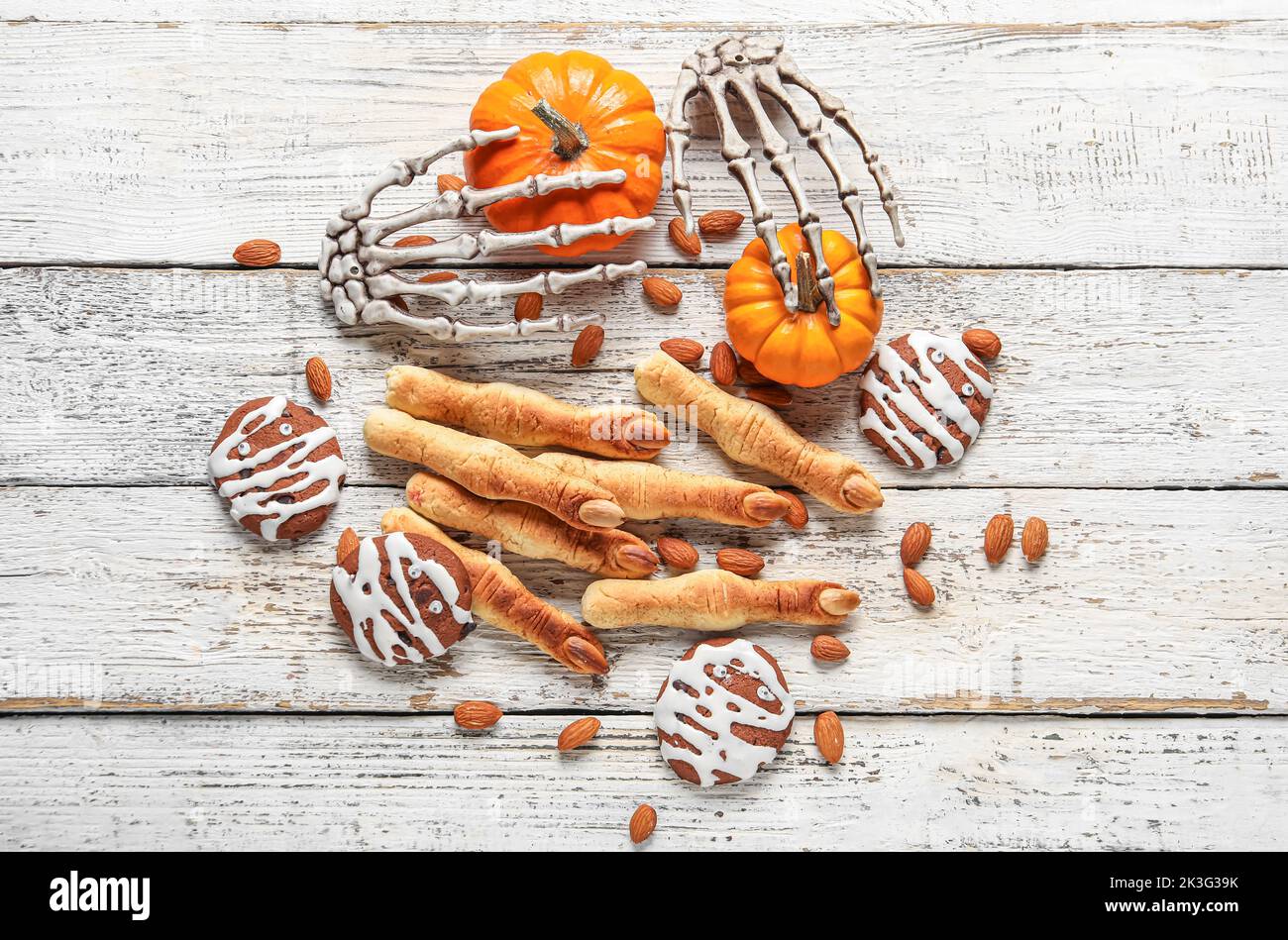 Halloween cookies with pumpkins, skeleton hands and almond nuts on ...