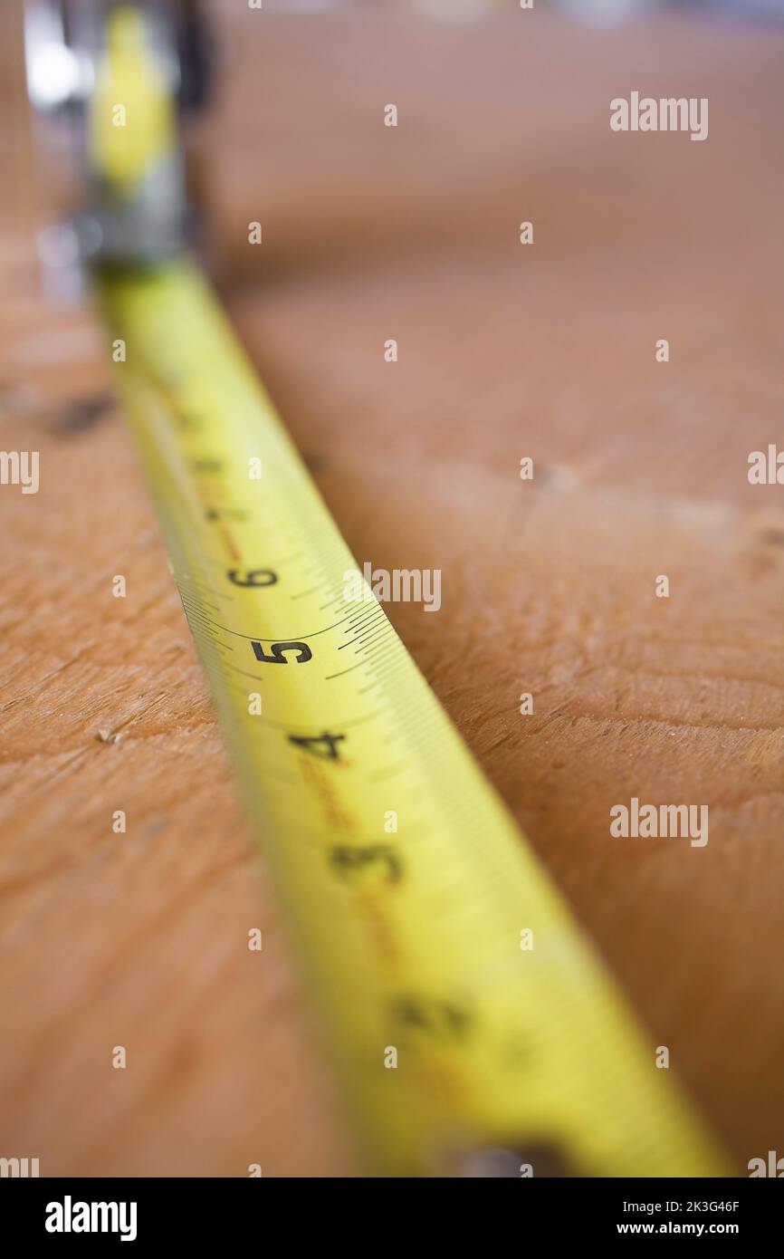 Close-up of extended construction tape measure on plywood floor inside ...