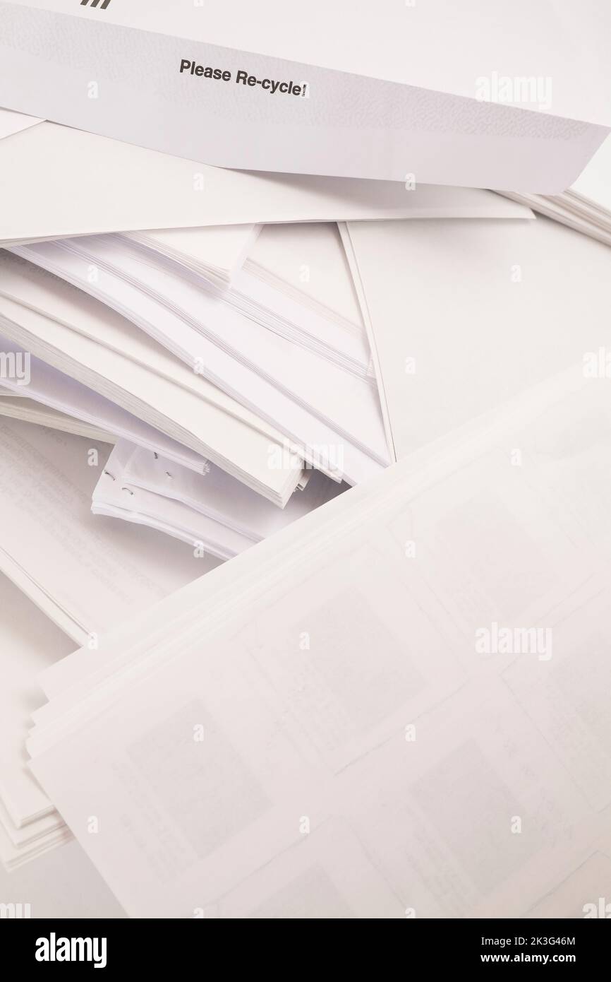 Please Re-cycle notice on top of a pile of stapled white paper sheet ...