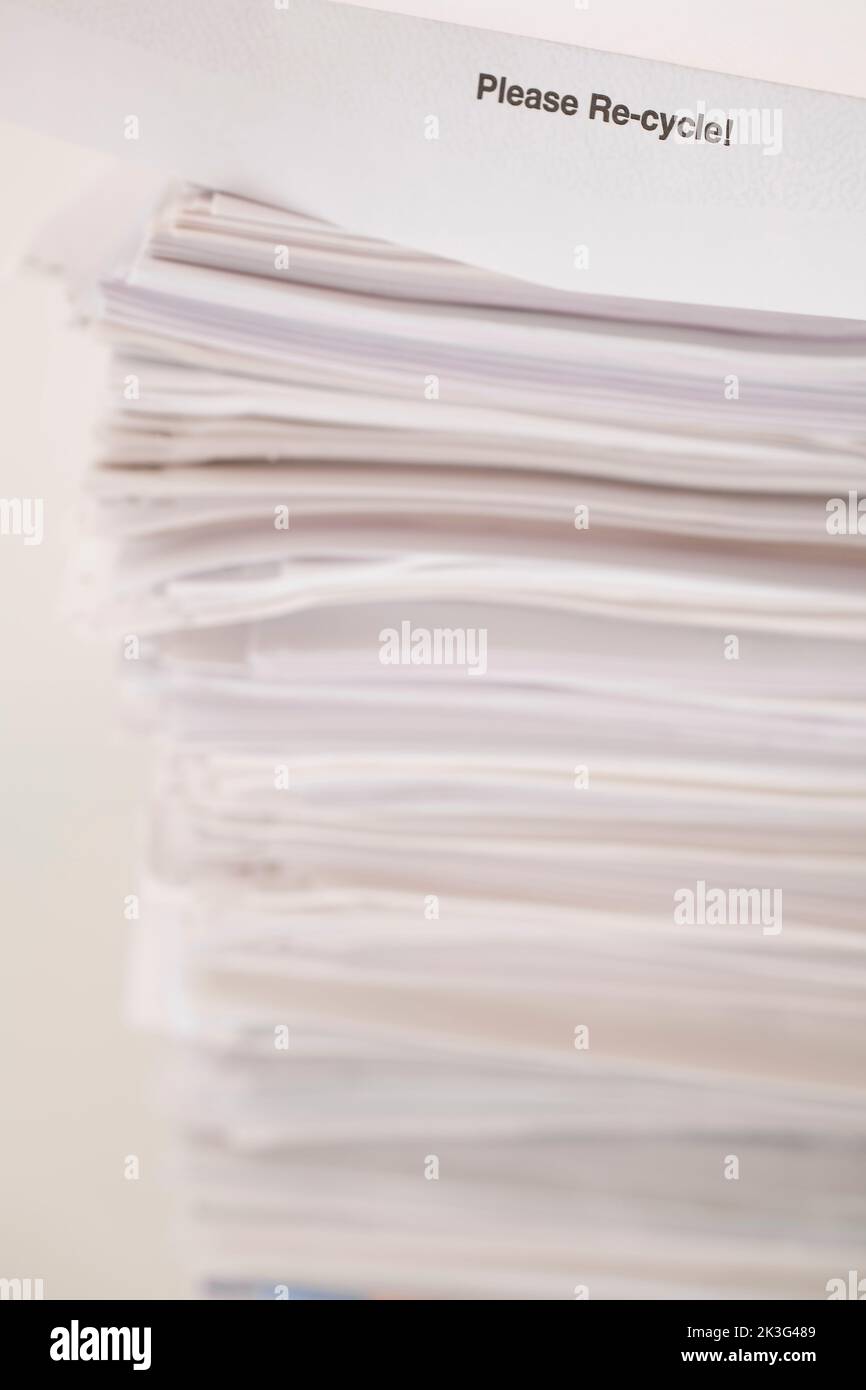 Please Re-cycle notice on top of pile of white paper sheet office ...