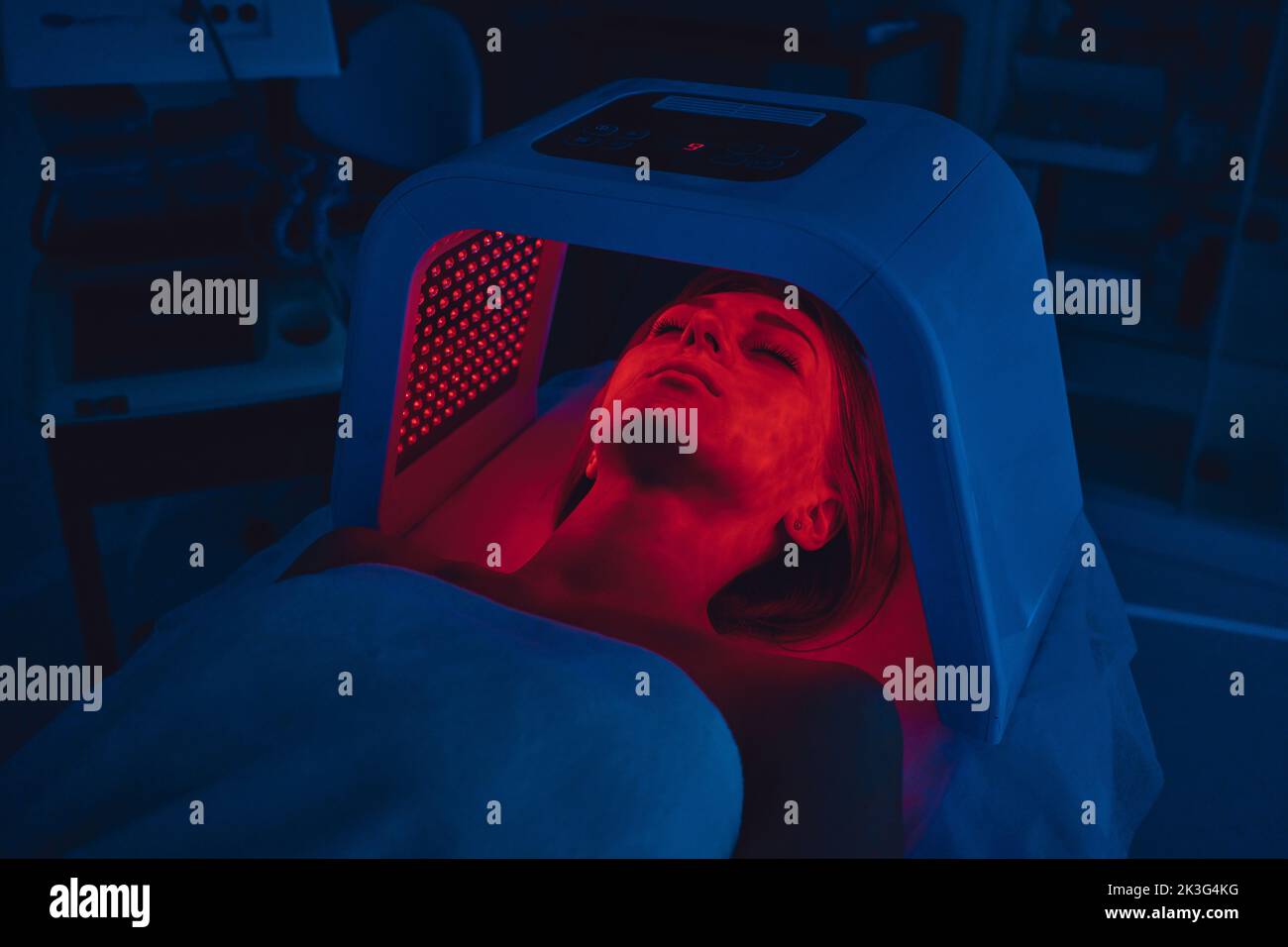 LED red light is treating the facial skin of a young woman Stock Photo ...