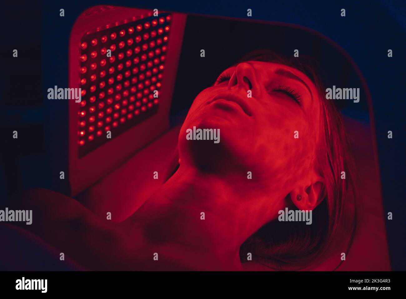 LED red light is treating the facial skin of a young woman Stock Photo ...
