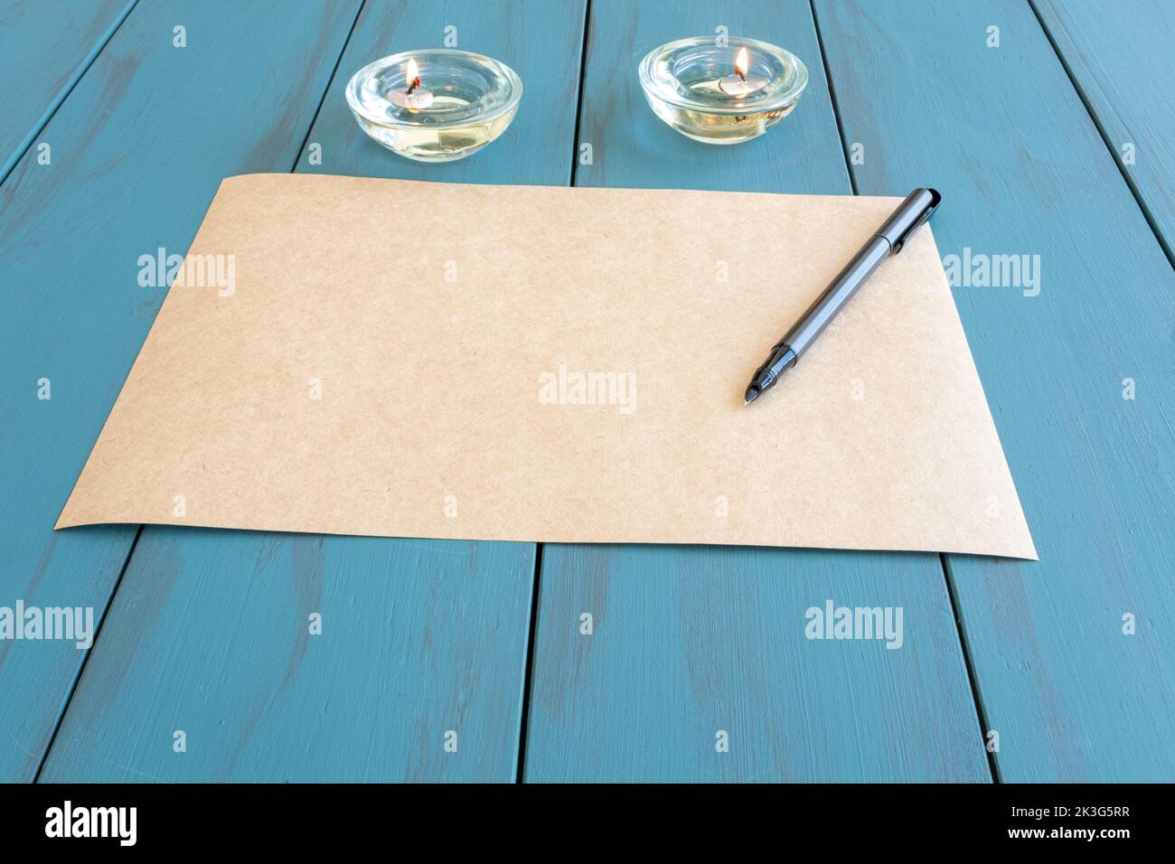 Fountain pen on brown paper, next to lit candles side view Stock Photo ...