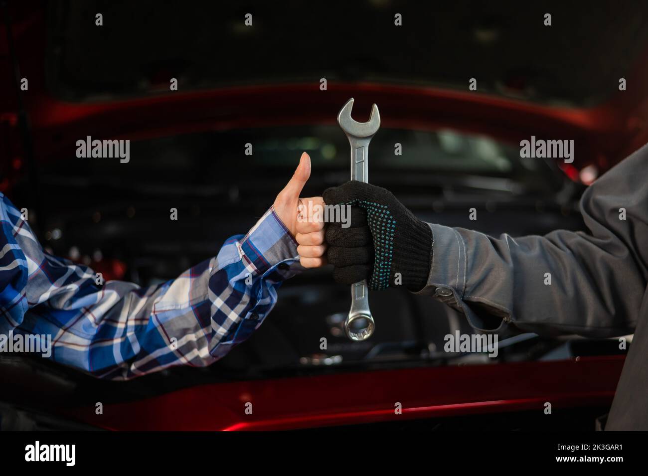 Close-up of woman's hand thumb up and mechanic's hand with tool ...