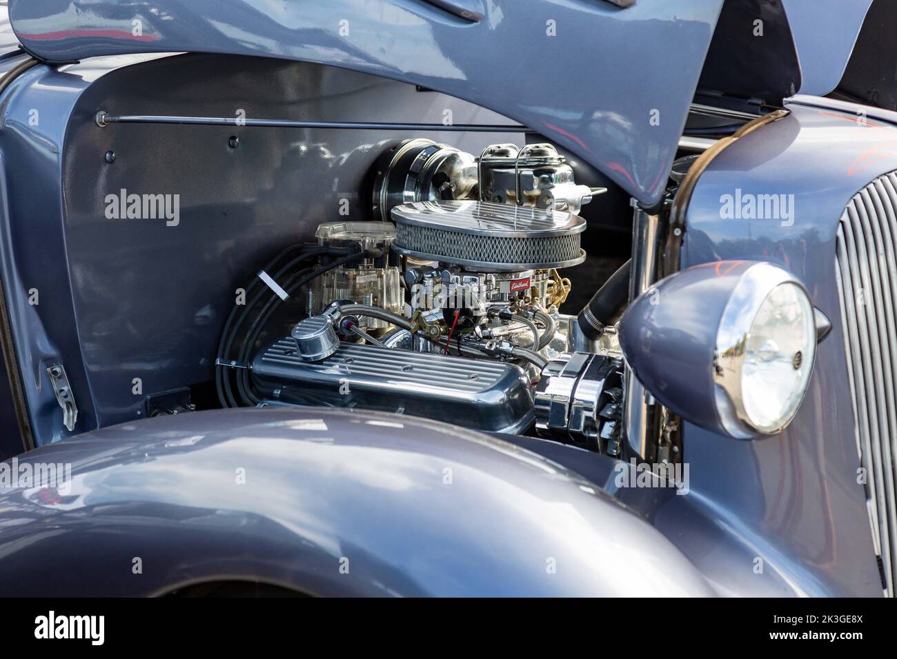 An open hood exposes the modified engine of a classic car Stock Photo ...