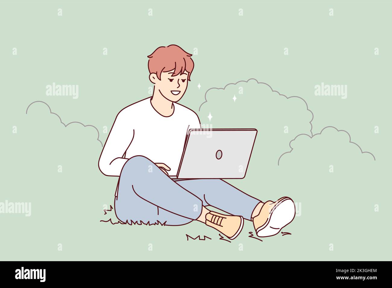 Smiling young man sit on grass in park working on laptop. Happy guy ...