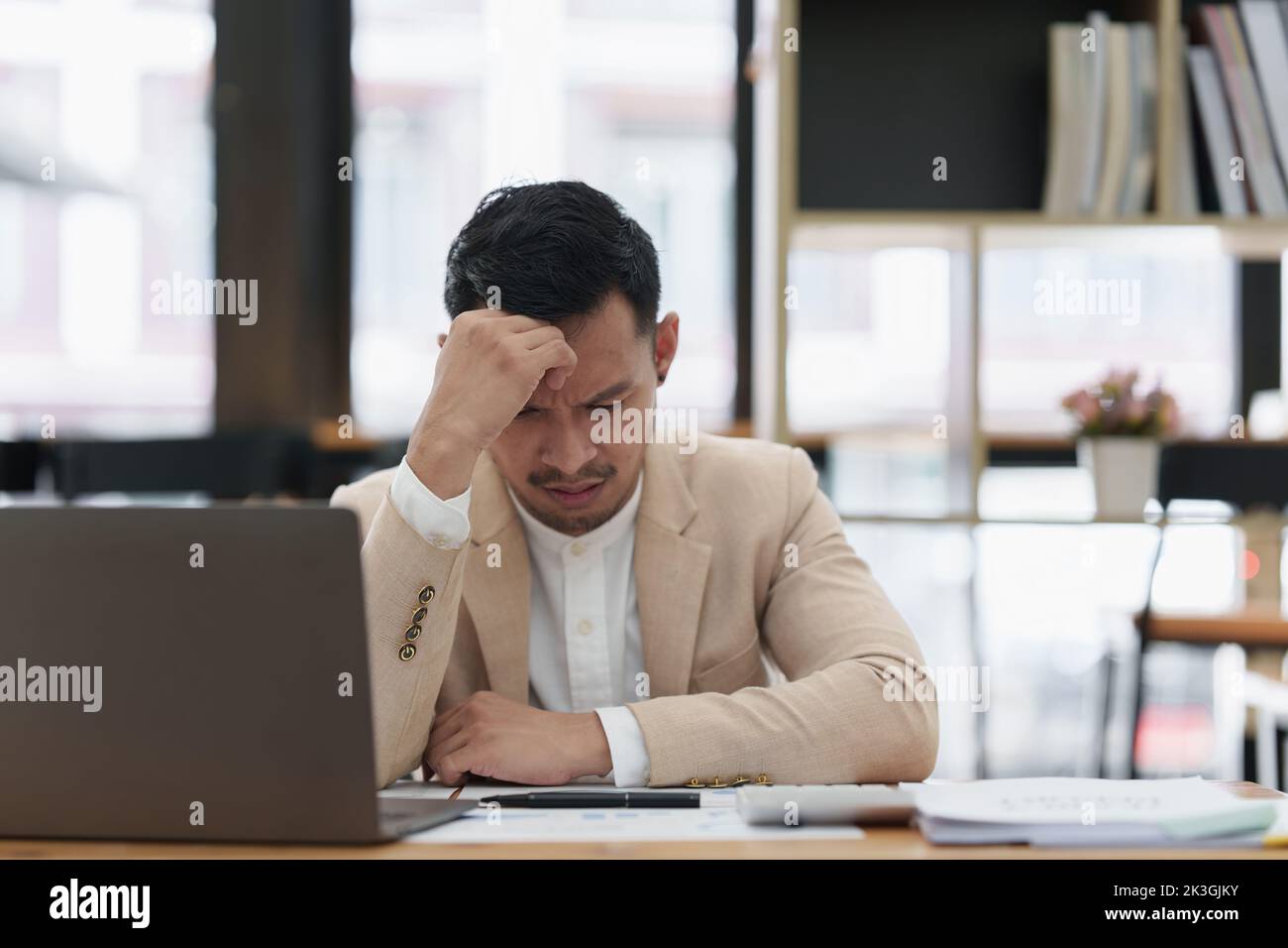 Stressed Asian businesswoman analyzes financial charts. Account and ...