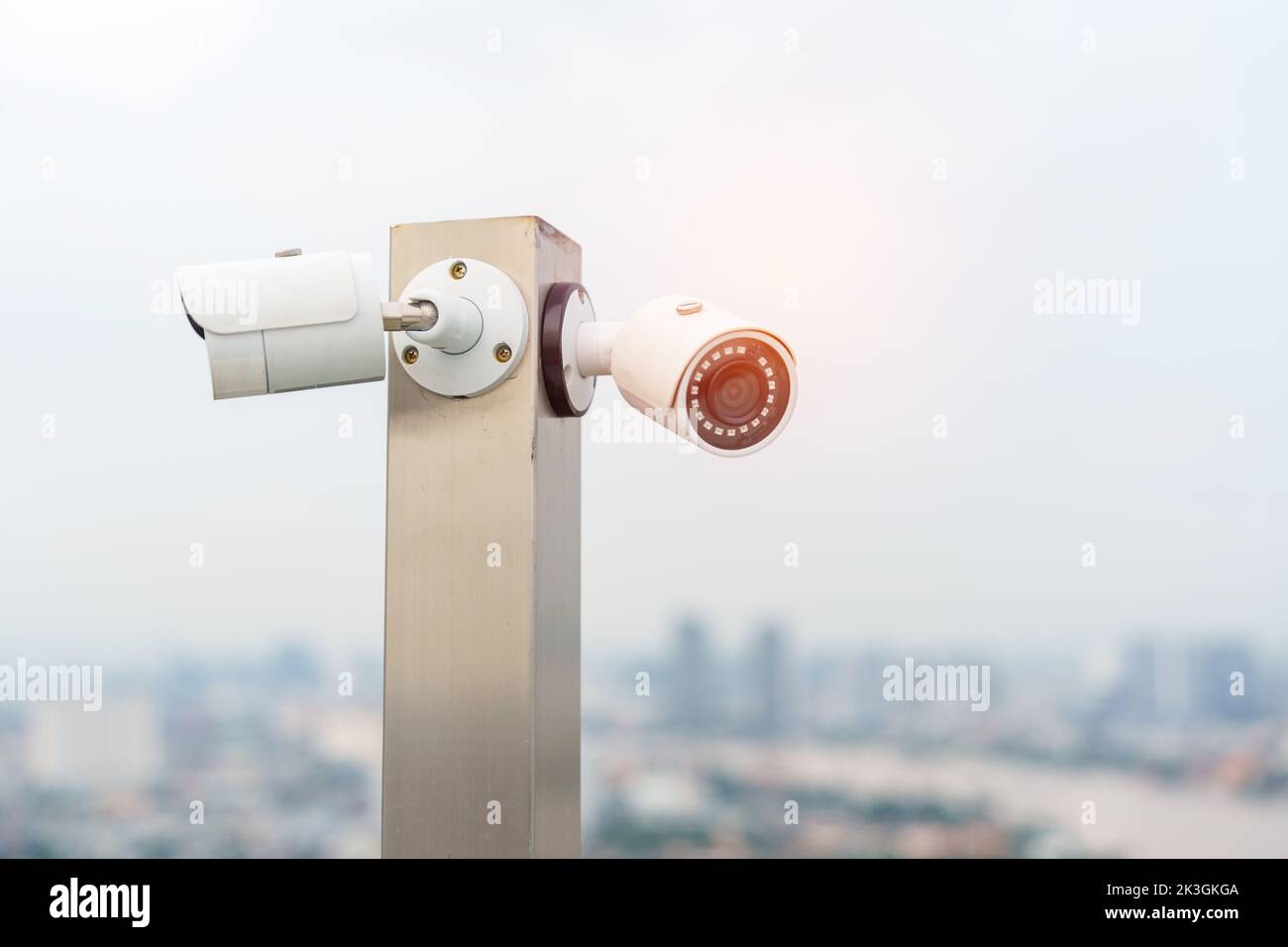 Modern CCTV camera against city and sky background. surveillance, video ...