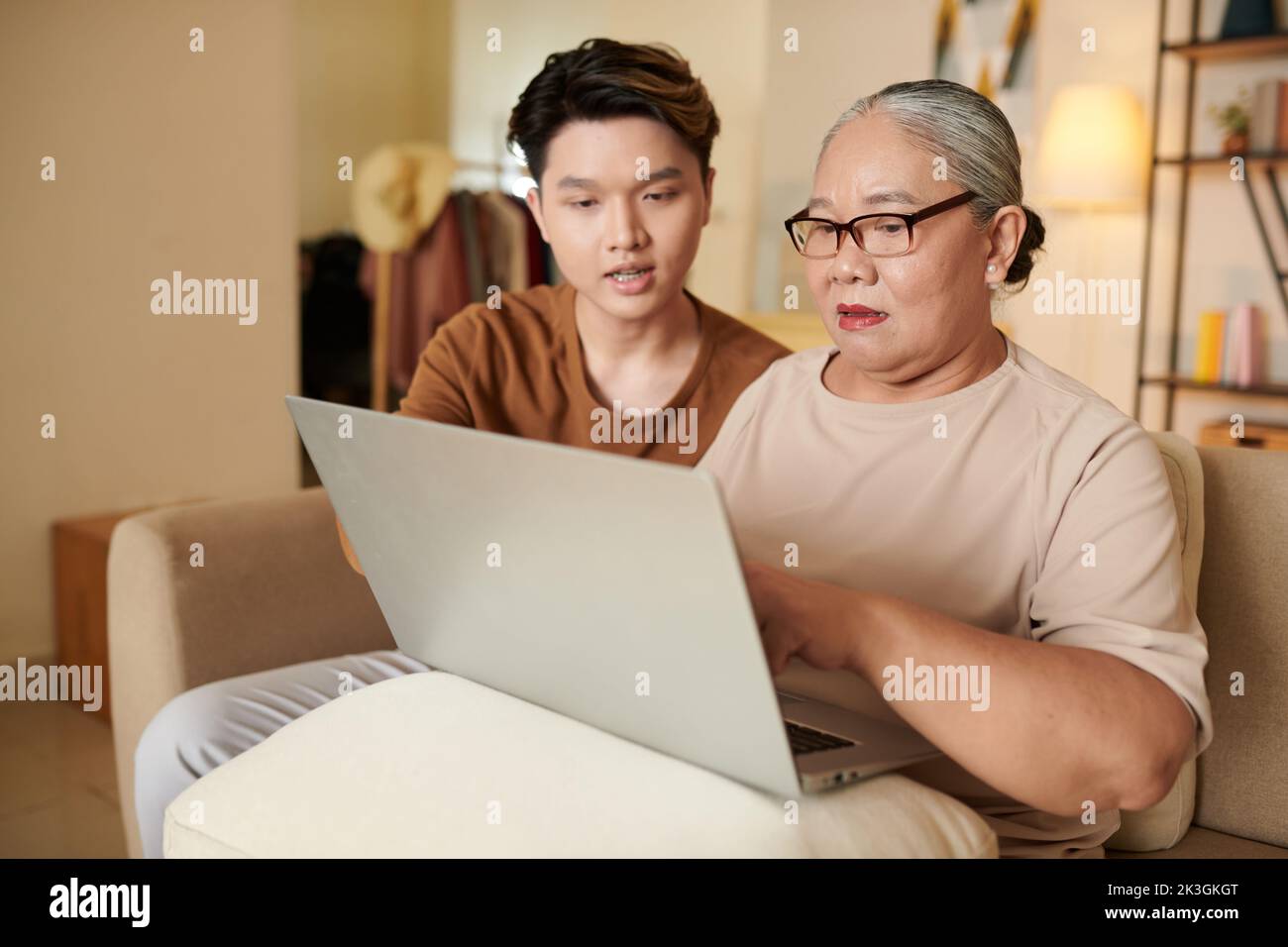 Grandson teaching grandmother how to work on computer Stock Photo - Alamy