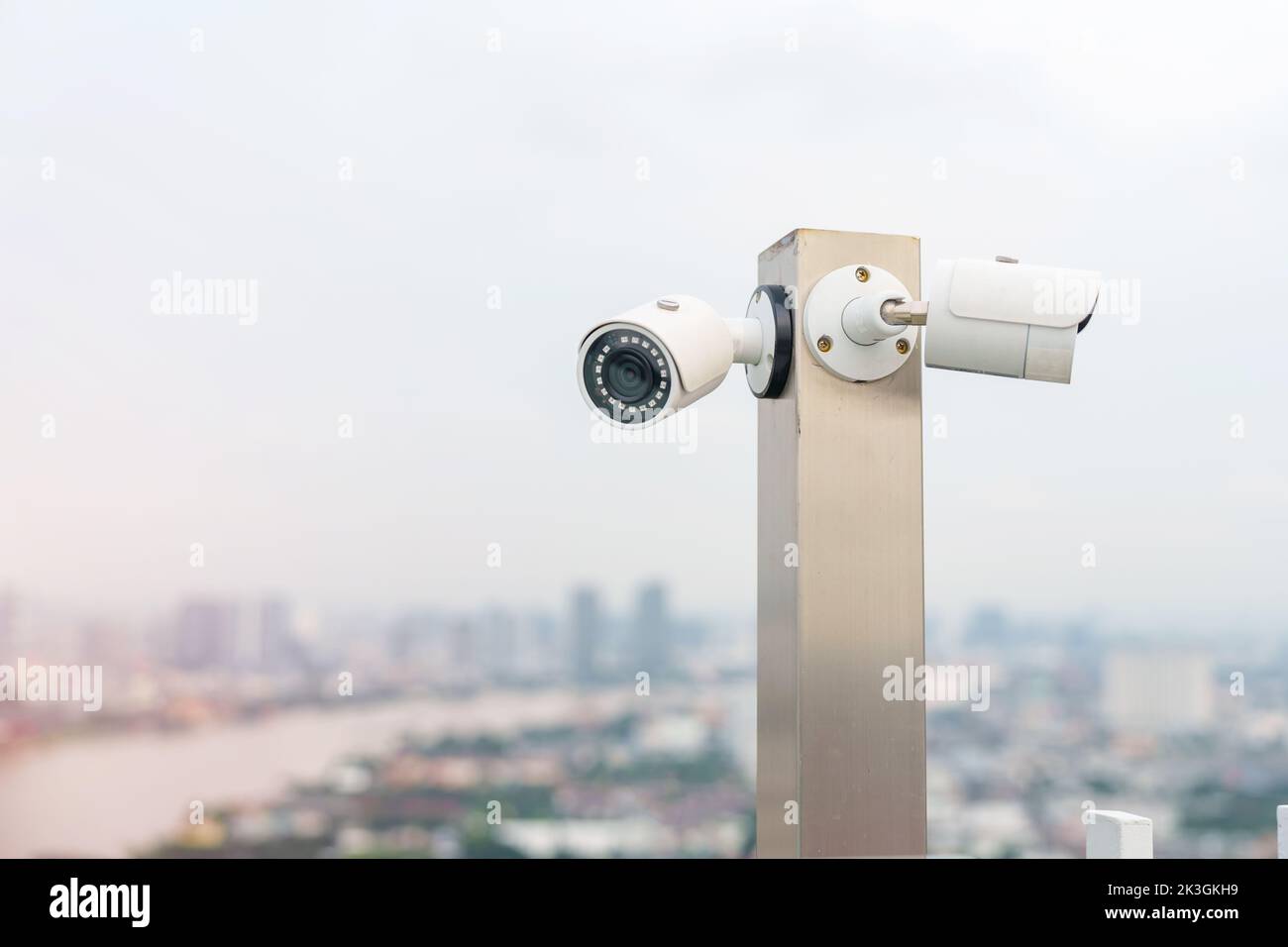 Modern CCTV camera against city and sky background. surveillance, video ...