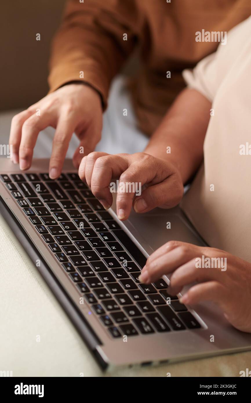 Closeup image of grandson explaining grandmother how to type on ...