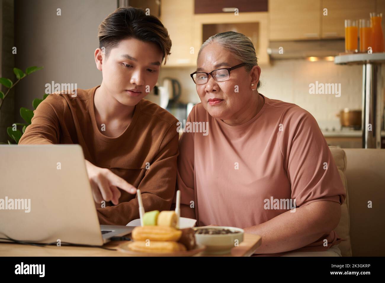 Young man setting wireless router in house in his grandmother and ...
