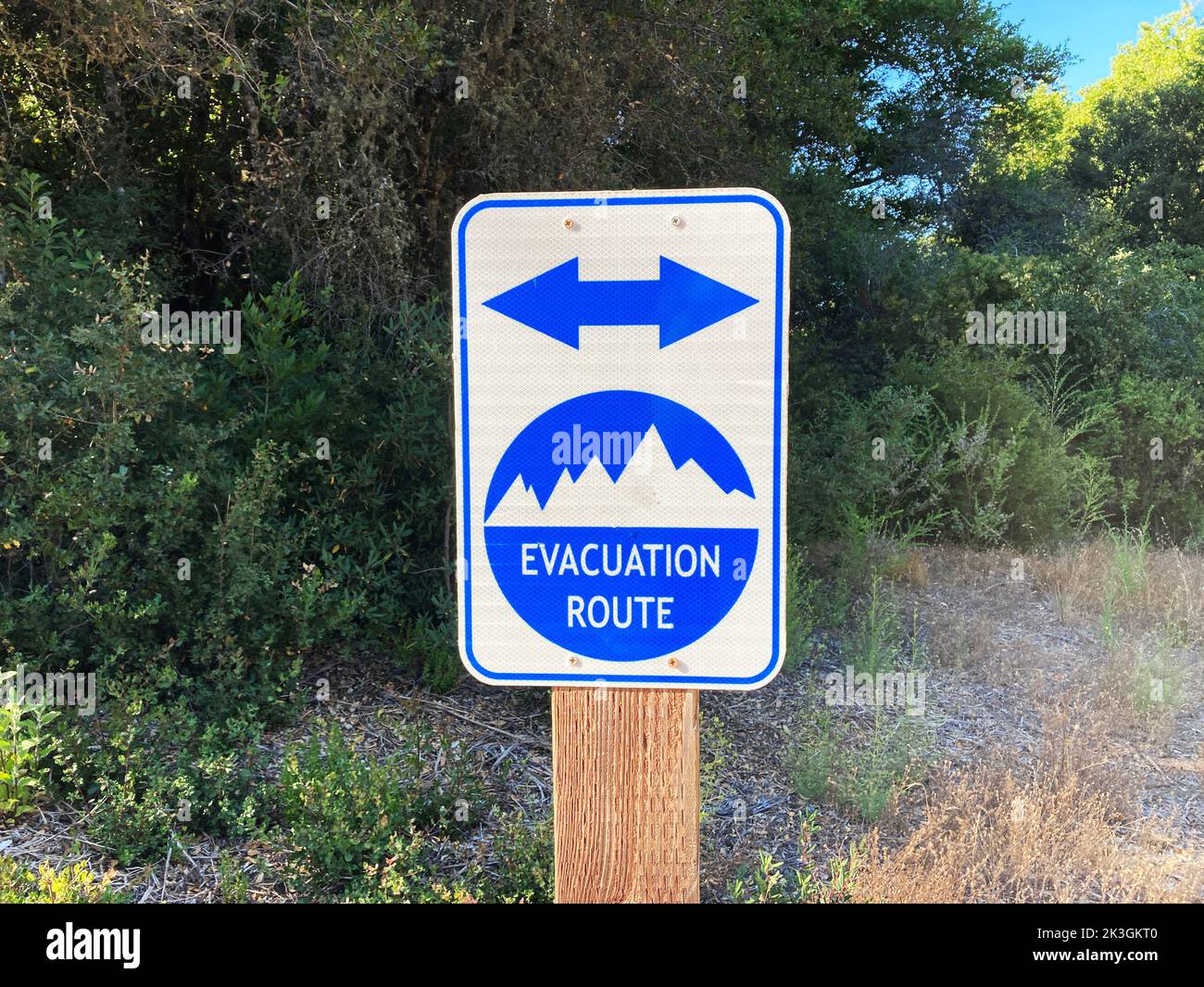 Blue evacuation route sign with left and rught arrows that point in the ...