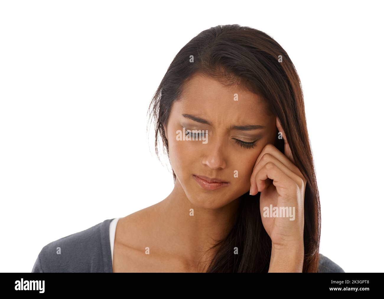 Suffering from a migraine. A young ethnic woman holding her temple ...