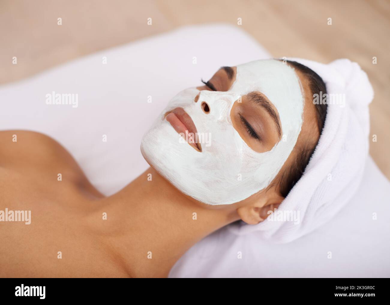 Relaxing at the spa. a young woman enjoying a facial treatment at a spa ...
