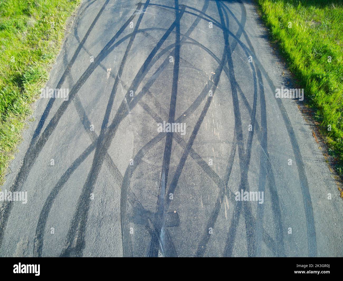Tyre marks on road aerial view showing skid mark patterns and green ...