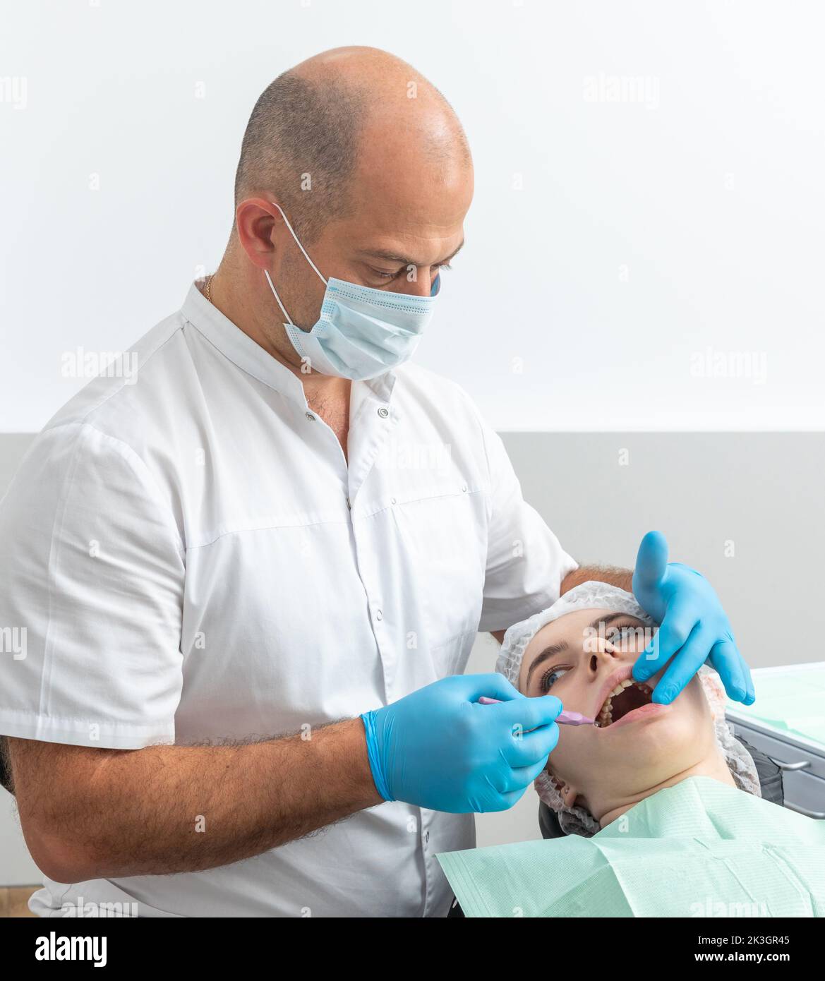 Male dentist looks at a jaw of female patient checking the bite Stock ...