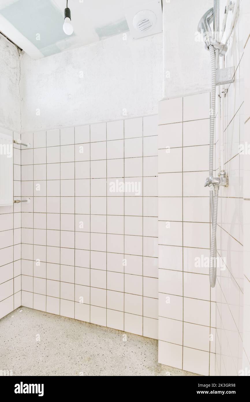 Shower faucets attached to tiled wall near glass partition and ...
