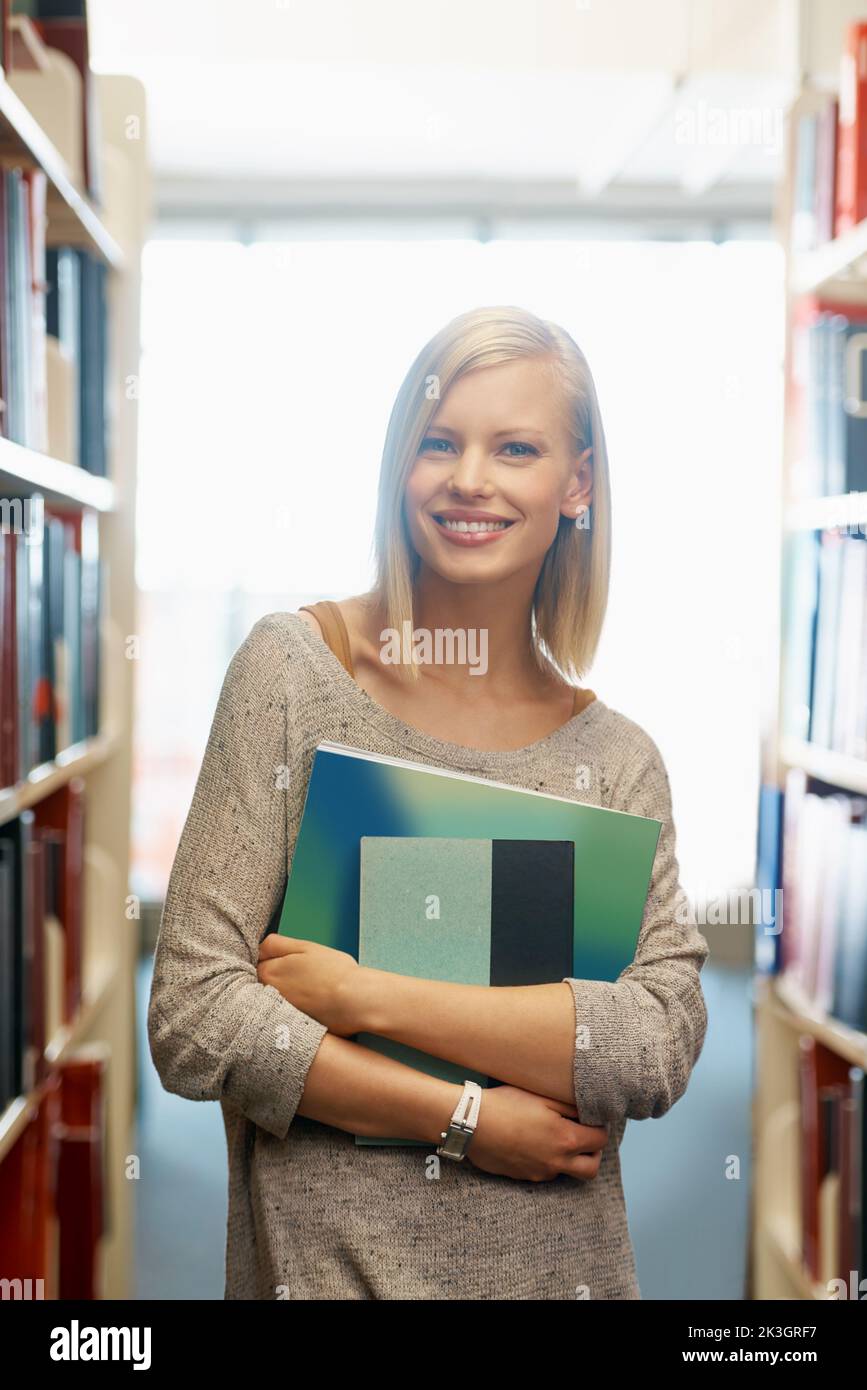 Getting together my study material. A young woman holding some books in ...