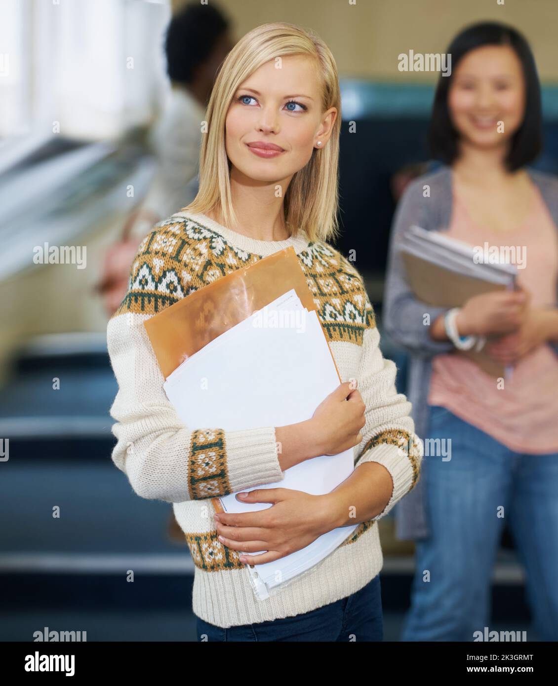 She loves learning. A young female student standing in the classroom ...