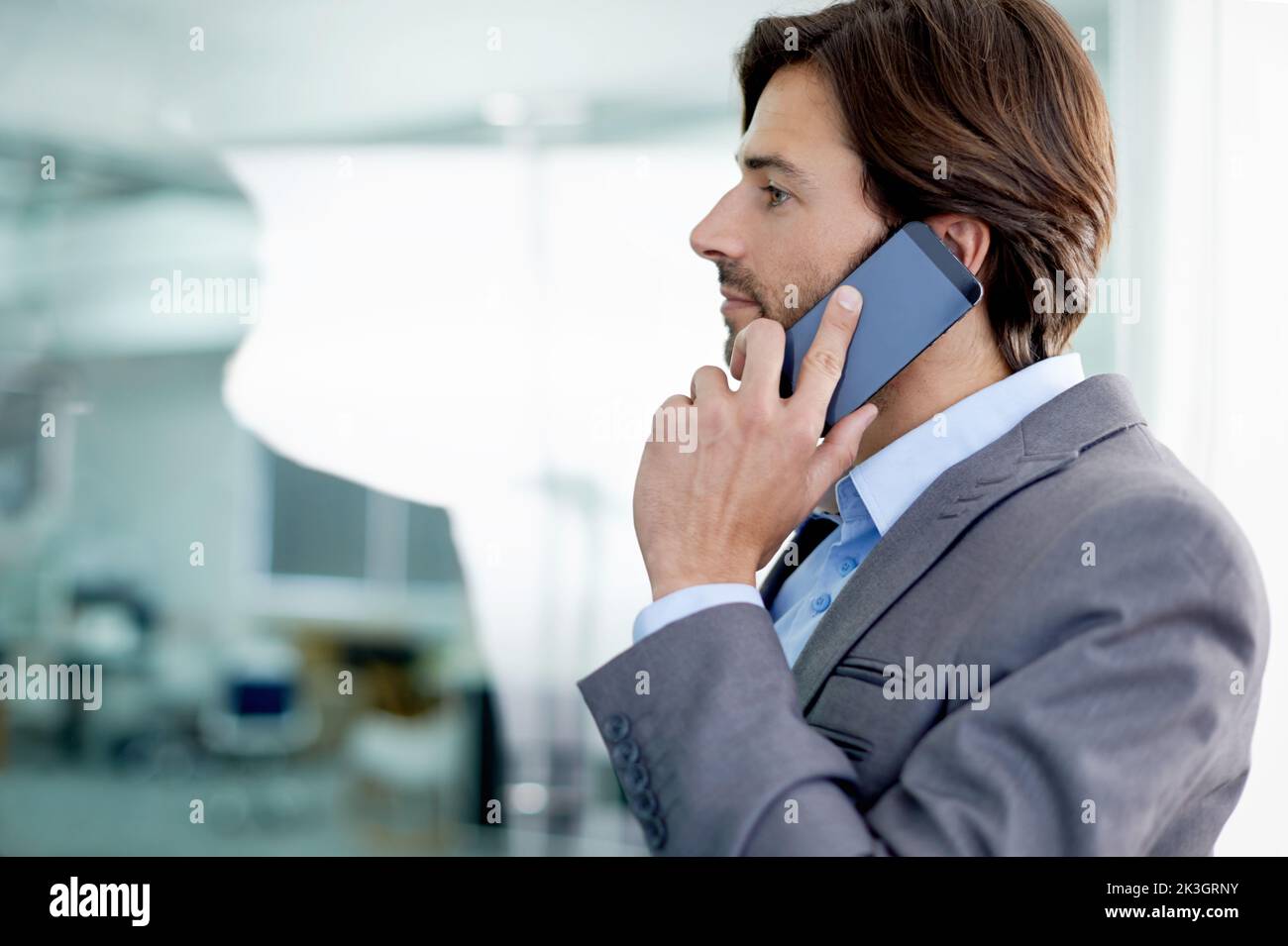 Contacting his clients. A handsome young businessman communicating via ...