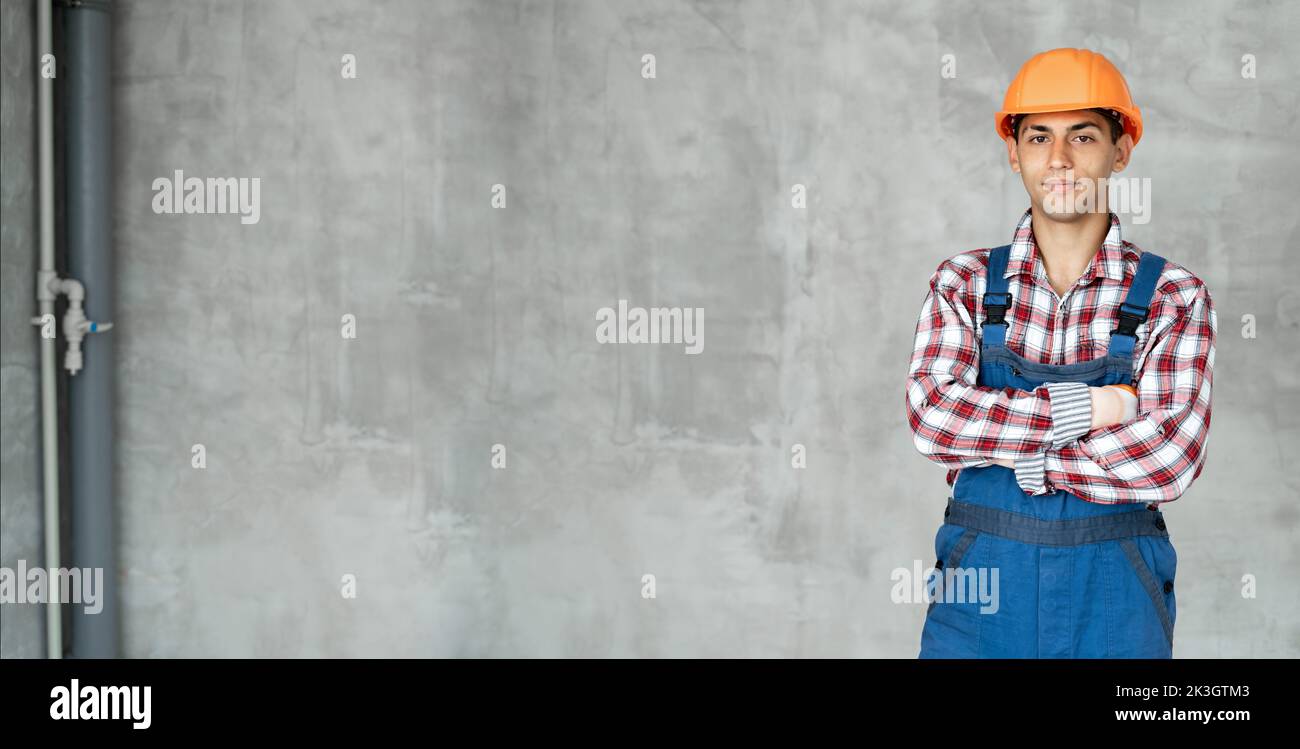Arabic construction worker portrait in overall and shirt having arms ...